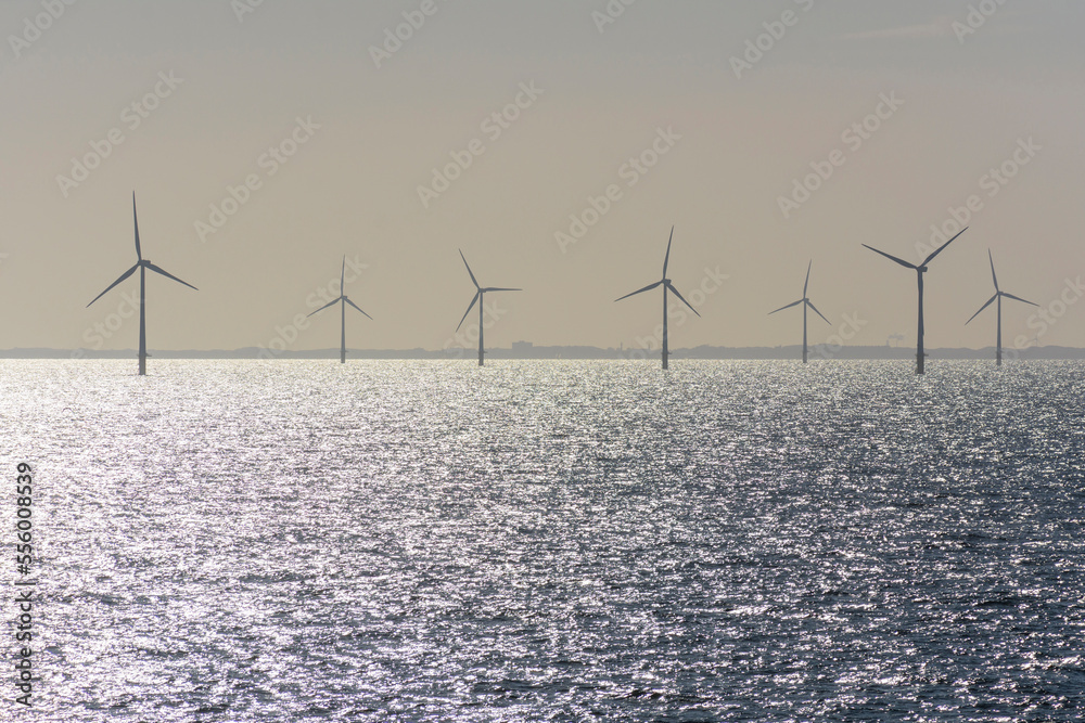Offshore wind turbine farm with sun shining on the North Sea on a hazy ...