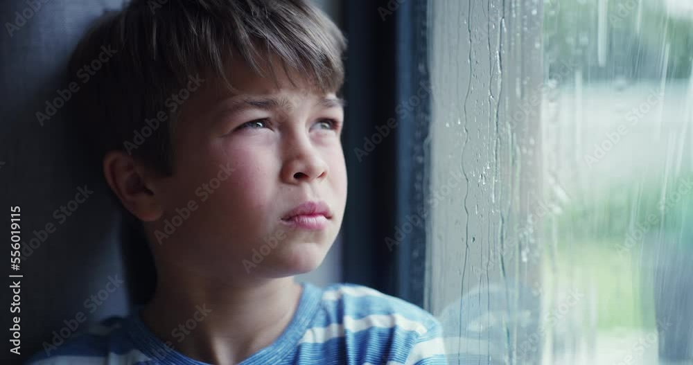 Video Stock Sad boy, window and bored on a rainy day, lonely and ...