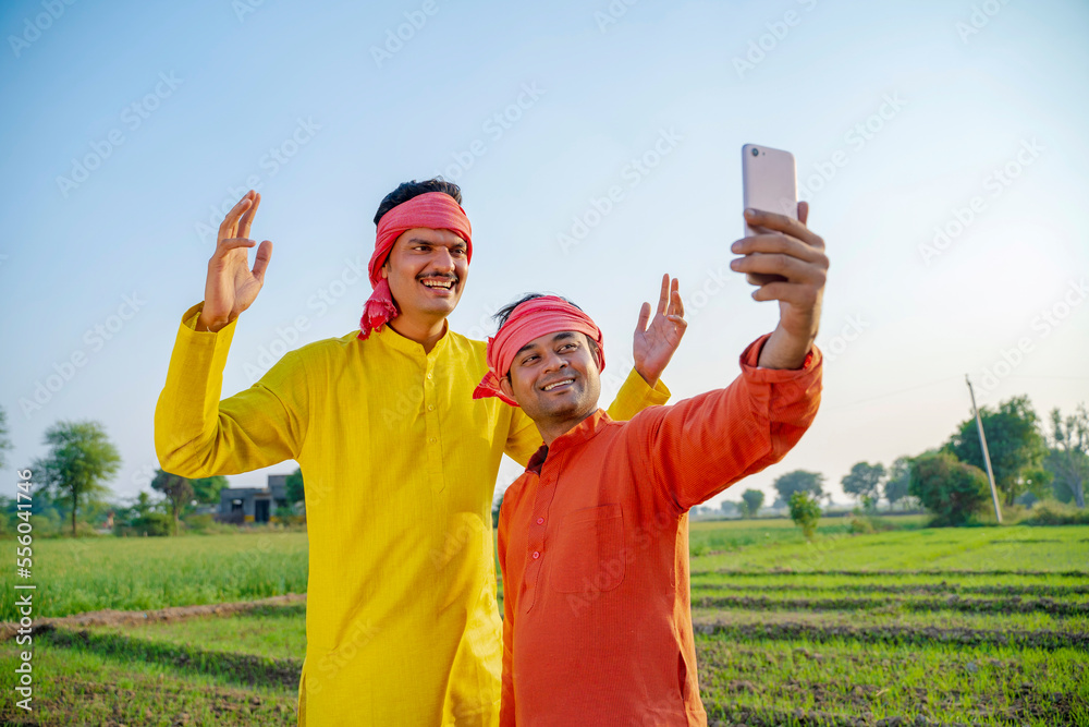 Two Indian farmers taking selfie in smartphone at agriculture field ...