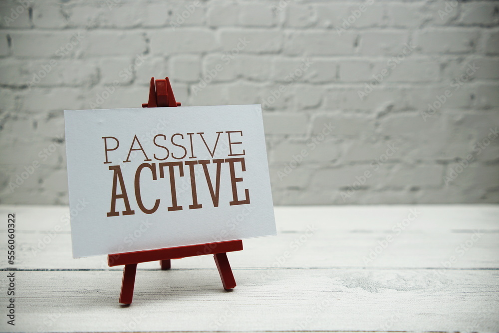Passive Active text on white brick wall and wooden background Stock ...