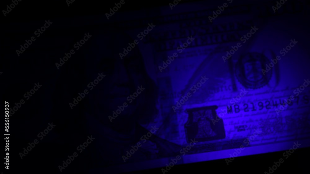 Examining one hundred dollar bill under ultraviolet light. Stock Video ...