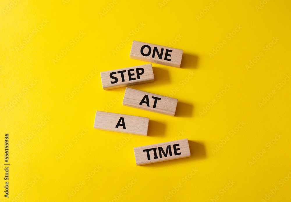 One step at a time symbol. Concept words One step at a time on wooden ...