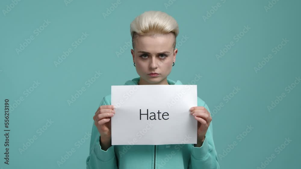 Close-up shot of a young, blonde-haired lady holding a white card with ...