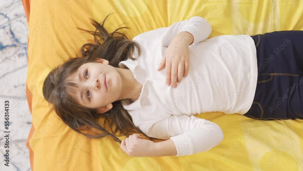 Beautiful cute little girl lying on her bed and daydreaming. Dreamy ...