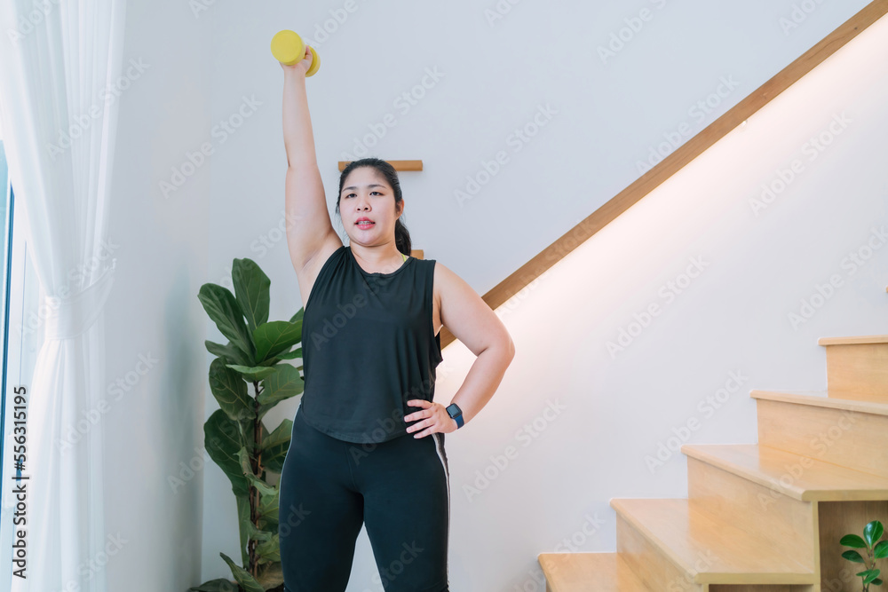 fat woman standing lifting dumbbell workout in living room. chubby ...
