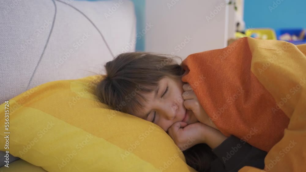 Having a bad nightmare, the little girl suddenly wakes up from her bed ...