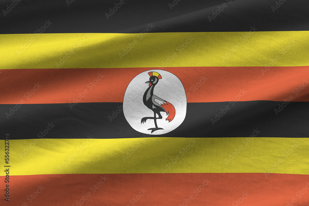 Uganda flag with big folds waving close up under the studio light ...