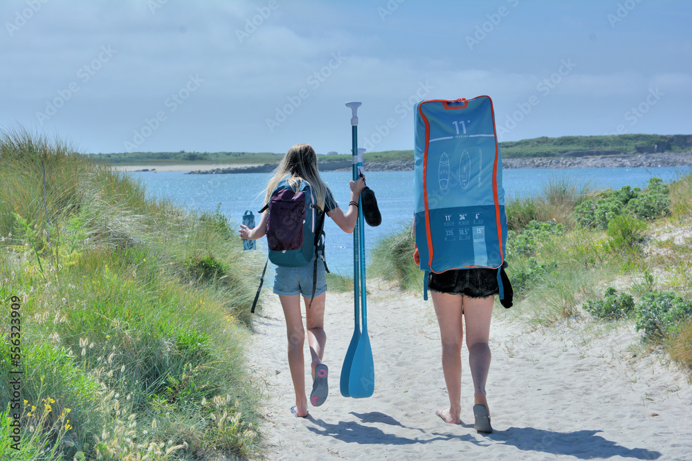 Jeunes filles qui vont faire du paddle sur une plage de Bretagne Stock ...
