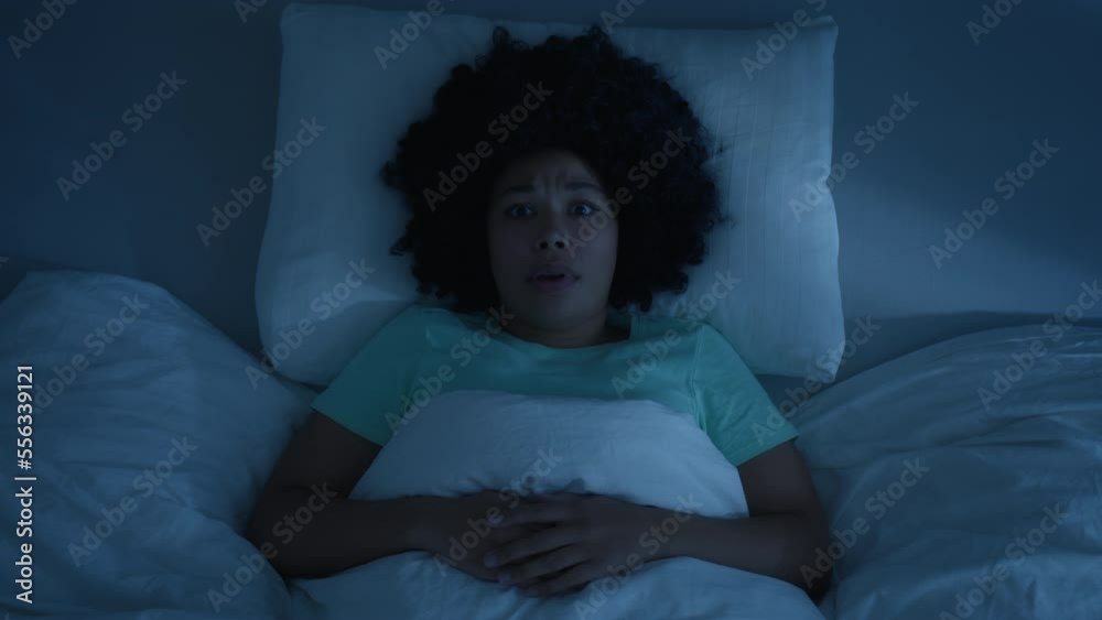Beautiful African American woman waking up through a nightmare on dark ...