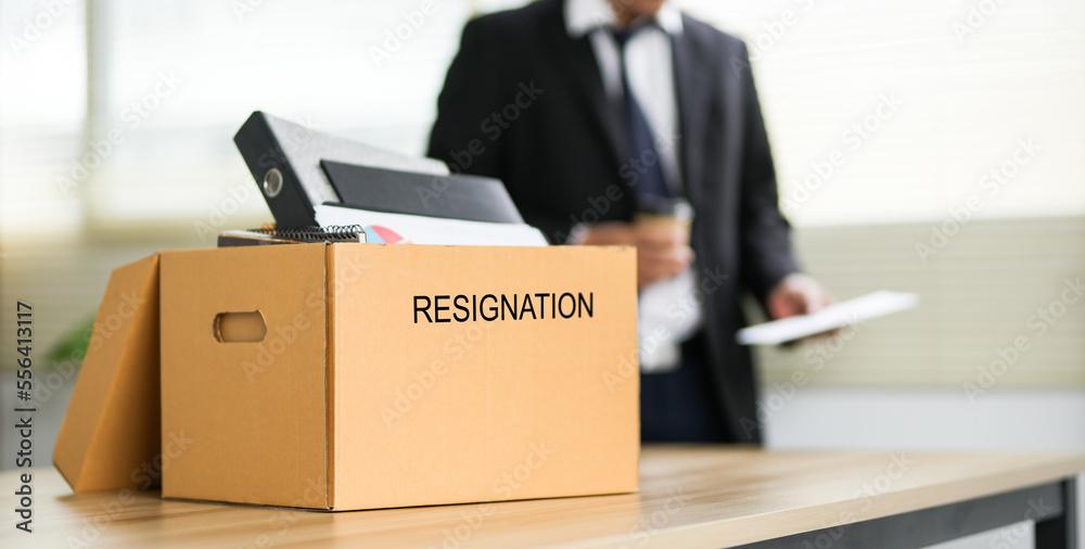 Resignation letter and cardboard box on the table, termination and ...
