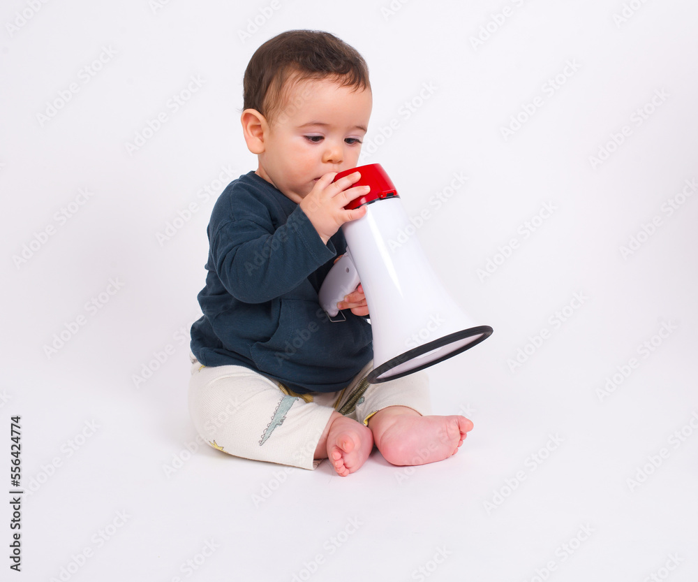 Cute adorable baby boy sitting on white studio background holding a ...