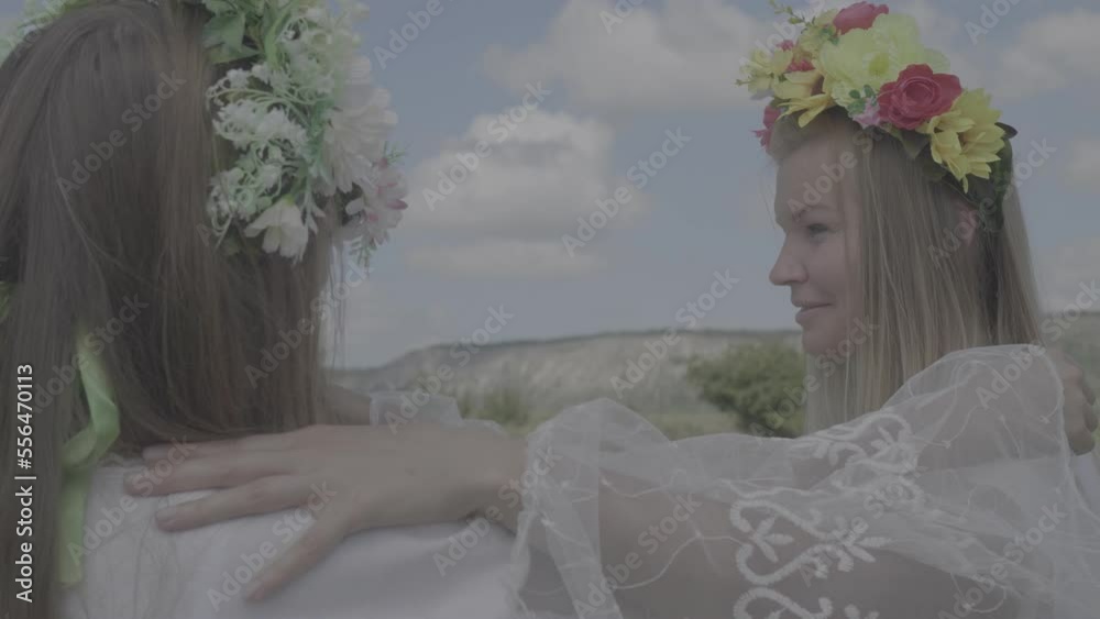 Three happy women in traditional costumes perform a traditional pagan ...