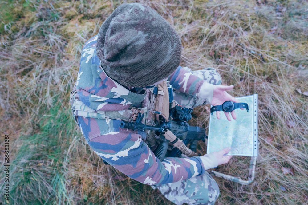 Soldier orients himself according to the map. A soldier works with a ...
