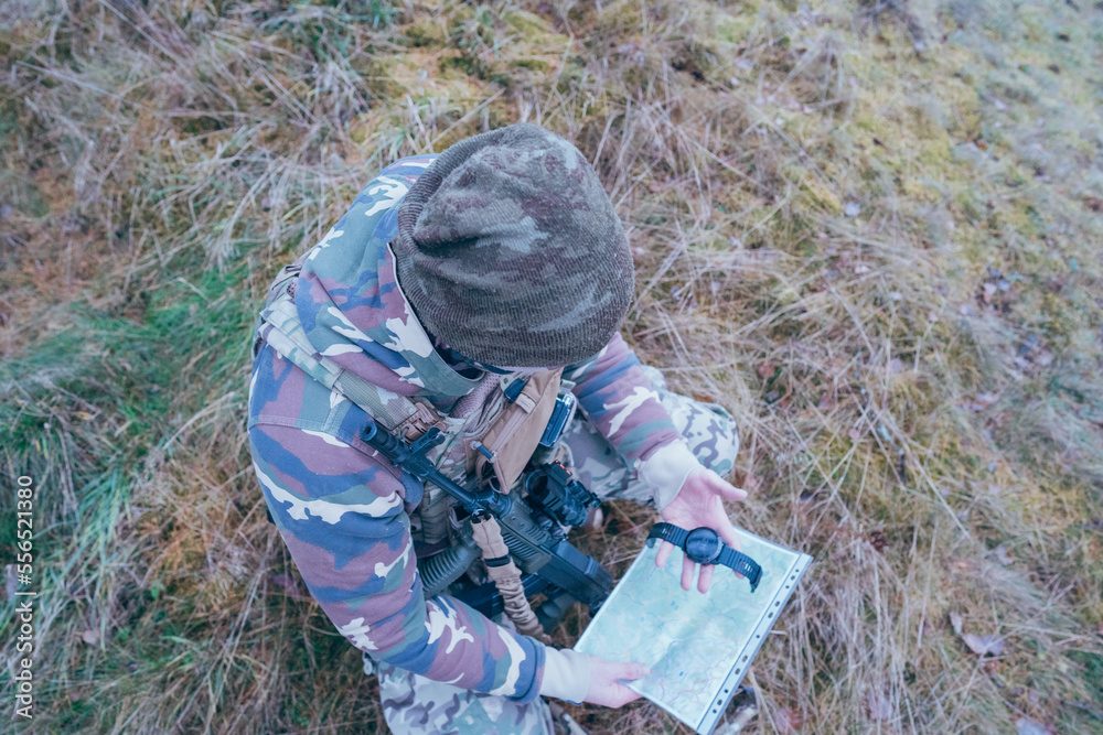 Soldier orients himself according to the map. A soldier works with a ...