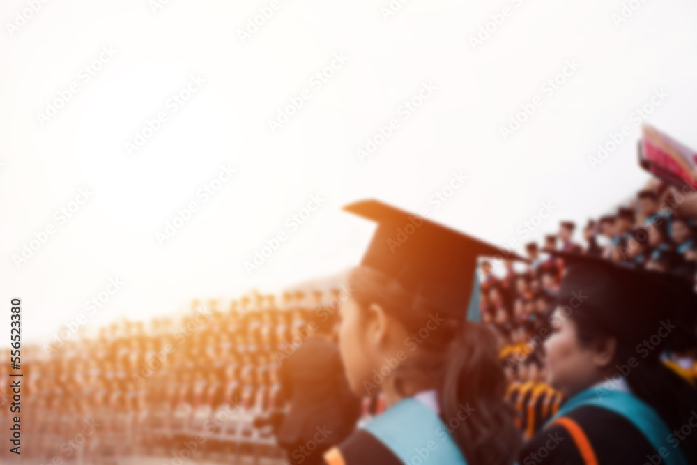 Blurred image behind the group of graduates celebrating their college ...