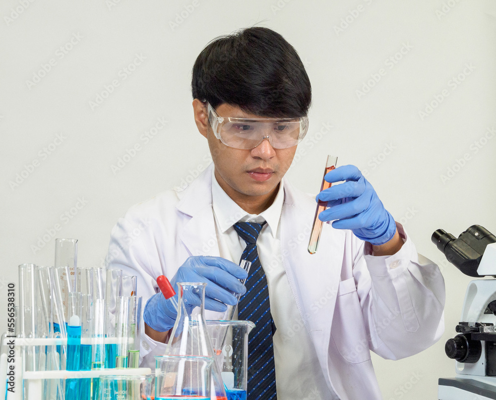 Asian male student scientist in reagent mixing laboratory In a science ...