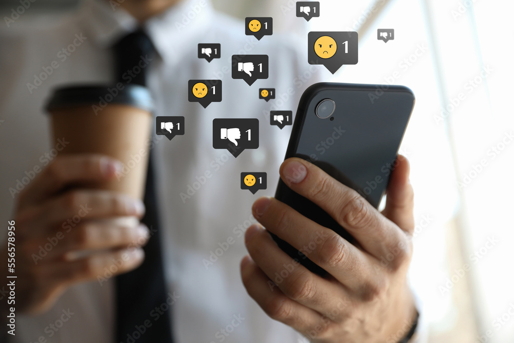 Social media dislike reaction. Man using mobile phone indoors, closeup ...