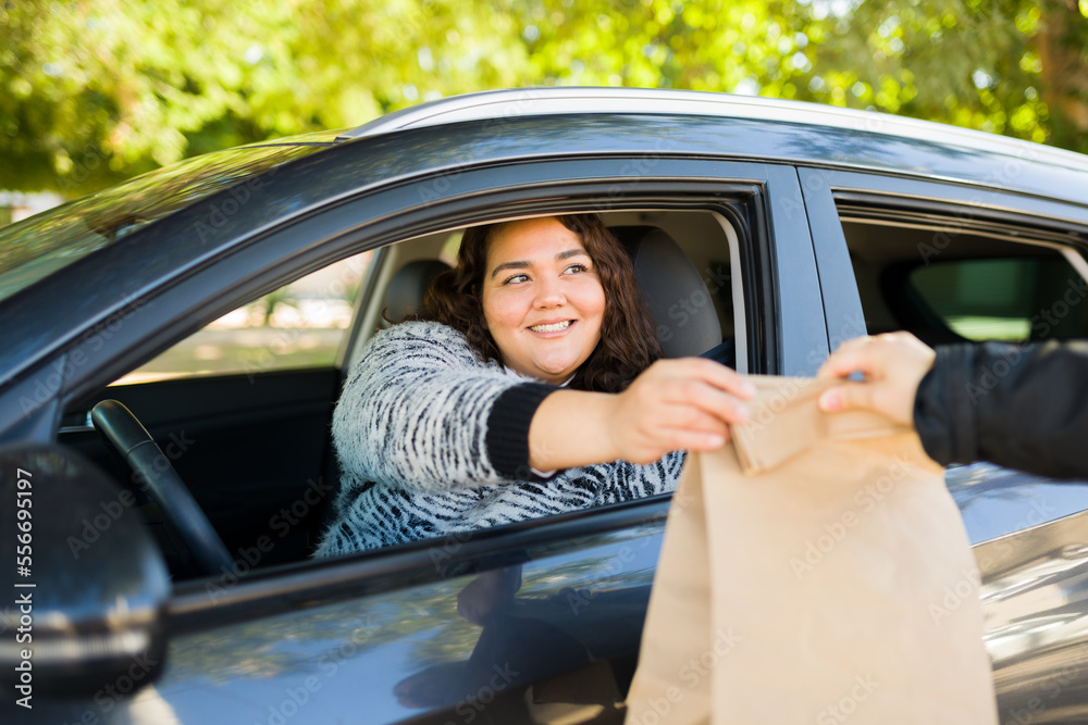 Happy fat woman in her car on the food drive thru Stock Photo | Adobe Stock