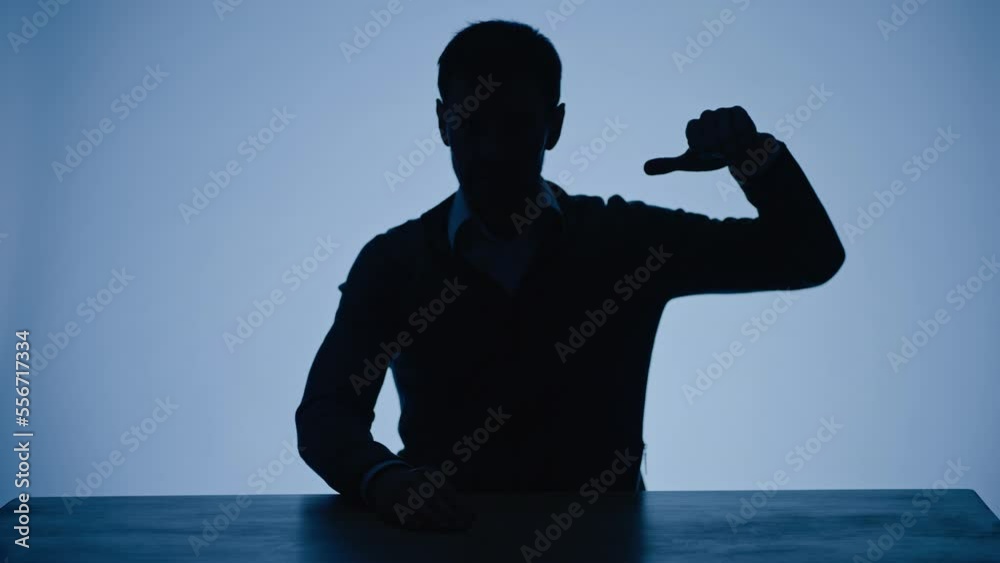 Silhouette of an angry man with obscured face showing at camera a hand ...