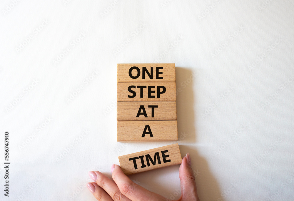 One step at a time symbol. Concept words One step at a time on wooden ...