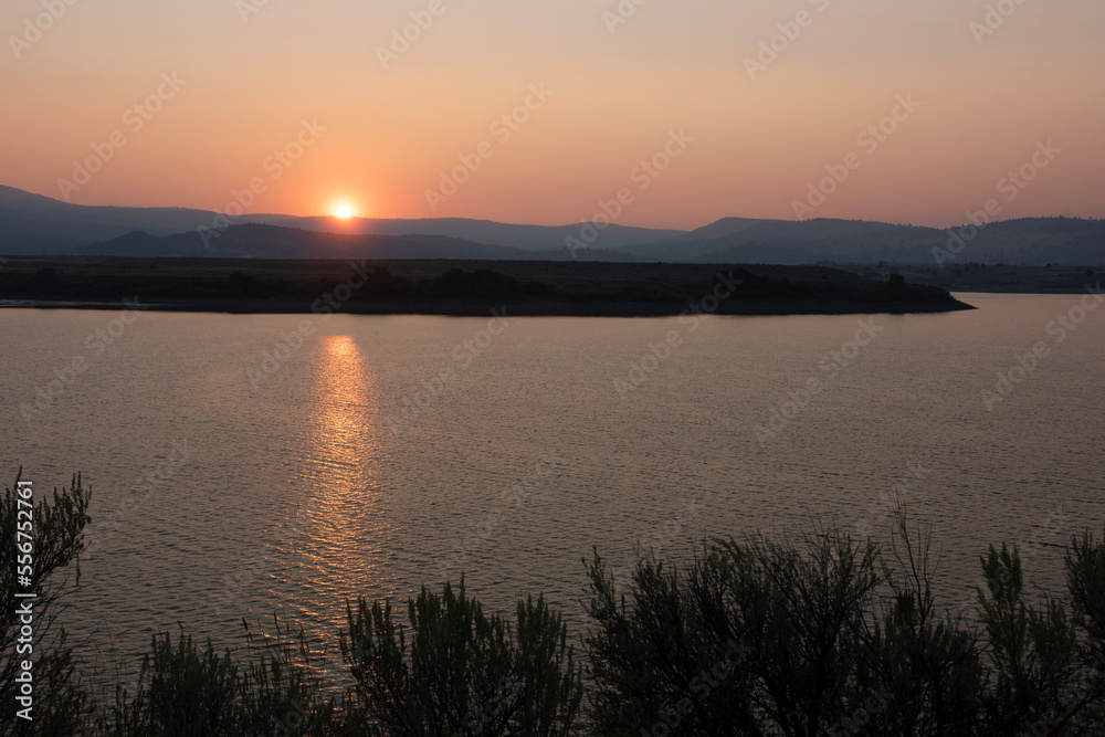 Smoky sky mutes the beautiful sunset reflecting over Unity Reservoir at ...