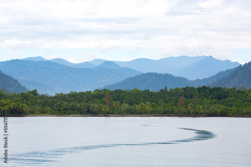 Jungle covered shoreline and hills along the shore of Morobe Bay ...