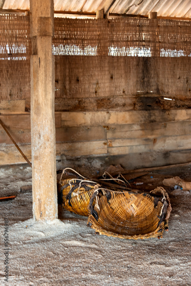 Rice and baskets on the ground in a farm storage building; Kampot ...