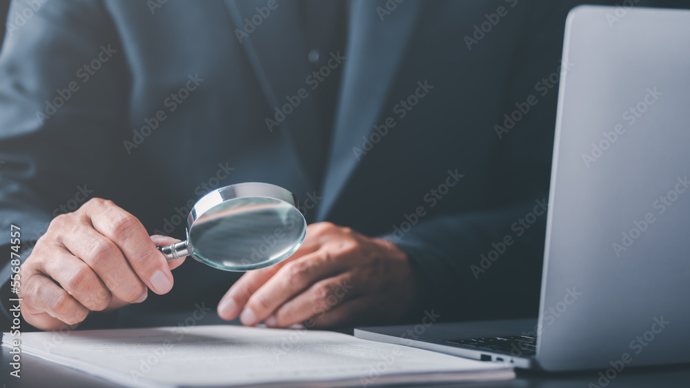 Businessman holding a magnifying glass,Audit Document Concepts, quality ... Businessman holding a magnifying glass,Audit Document Concepts, quality ...