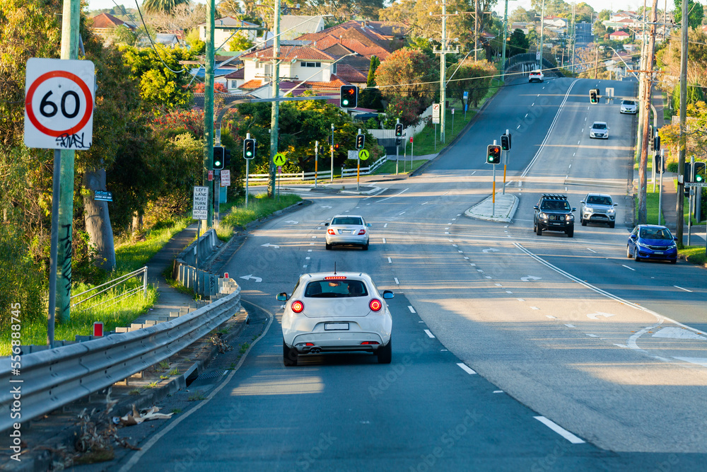 Foto de 60 speed sign and cars driving down double lane road with ...