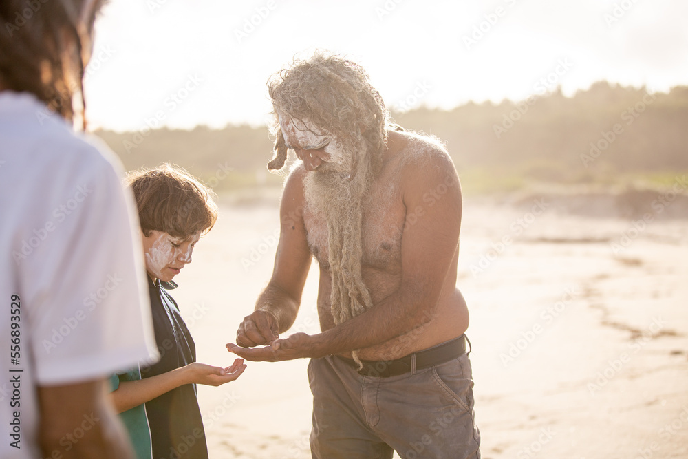 Aboriginal father helping son on a beach Stock Photo | Adobe Stock