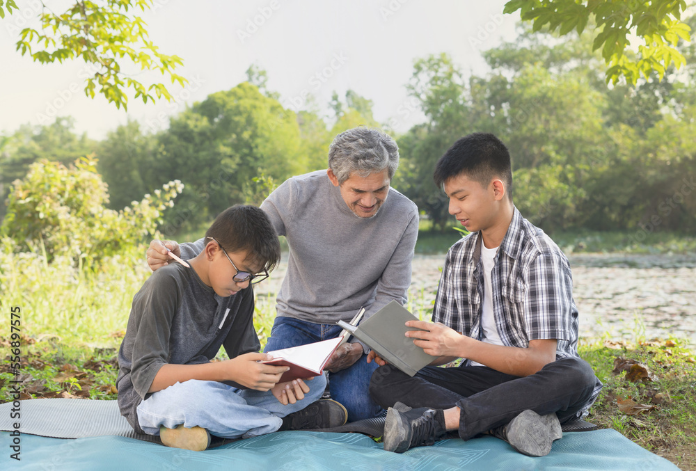 senior pensioner grandfather is explaining grandsons a lesson at their ...