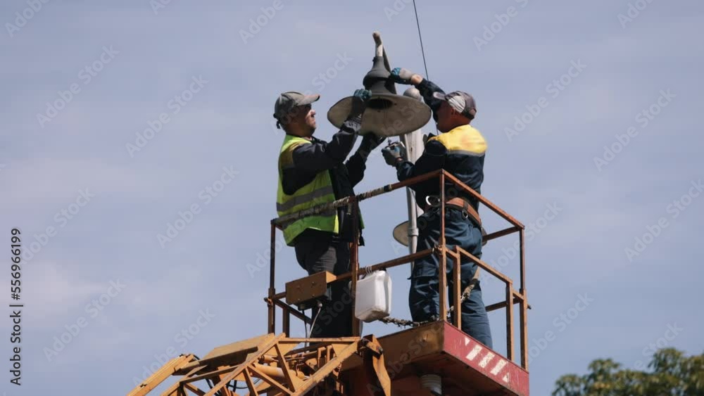 Technician on aerial, fix light, lift bucket. Street light repair work ...