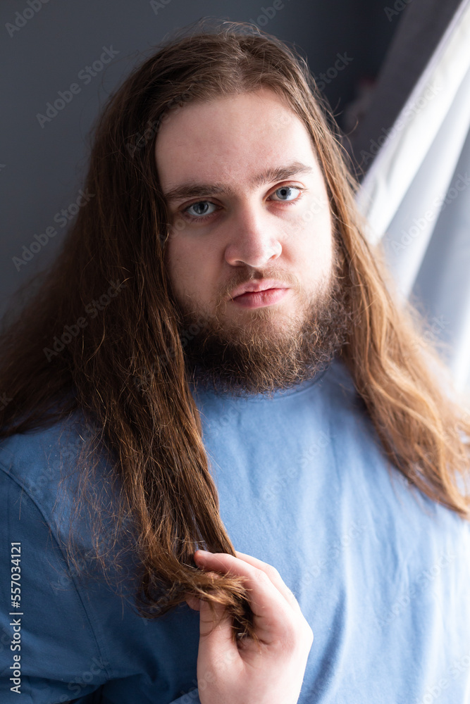 Vertical medium portrait of bearded and husky young man standing next ...