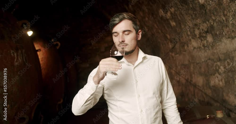 Happy successful male winemaker is tasting a flavor and checking fresh ...