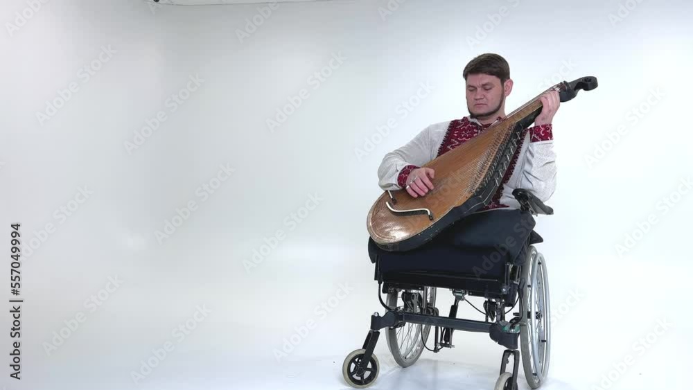 invalid handsome young man with kobza musical instrument in hands sits ...