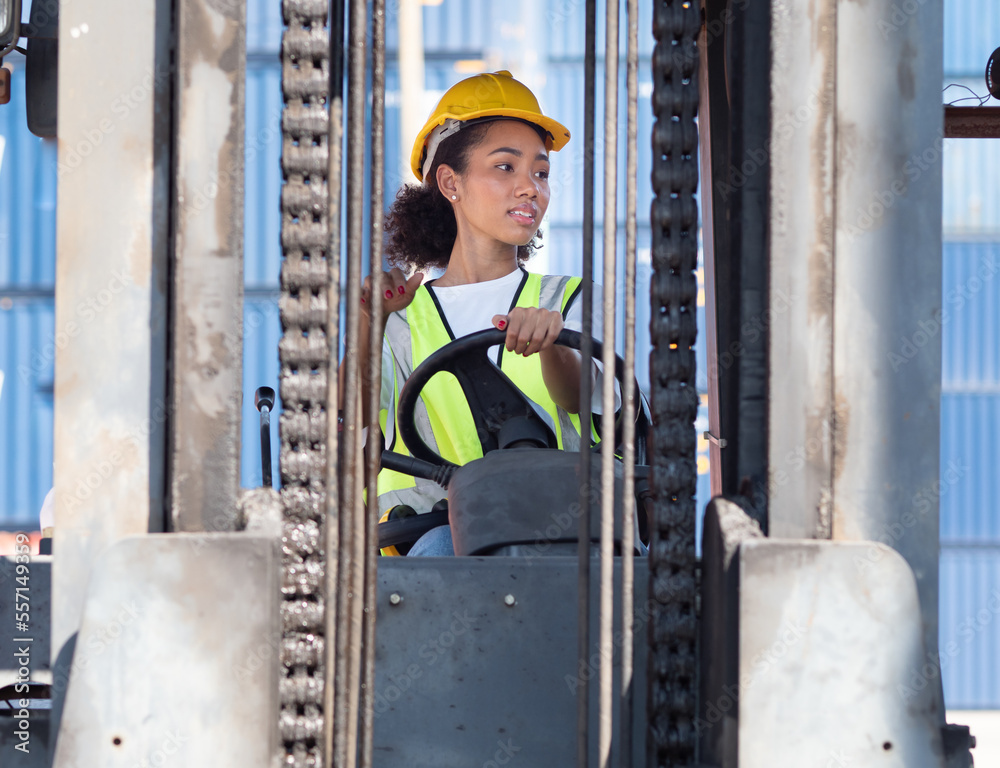Young female foreman employee driving forklift at shipping container ...