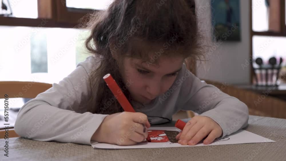 Little girl consternated on drawing. Using marker to draw a butterfly ...