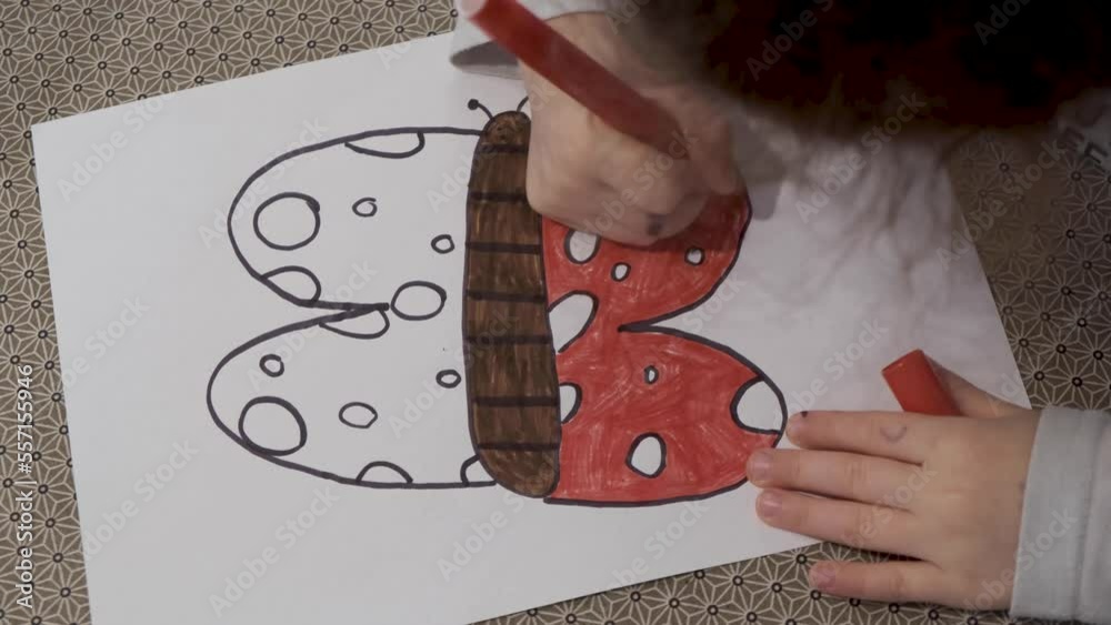 Butterfly drawing made by a kid. Little hands coloring in a drawing ...