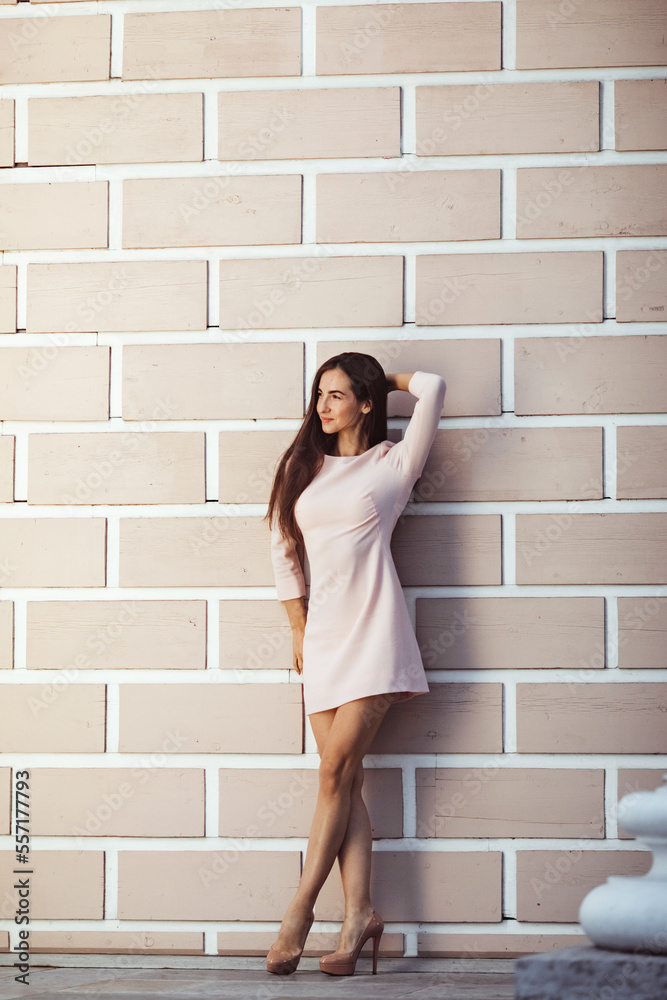 beautiful young woman against white brick wall Stock Photo | Adobe Stock