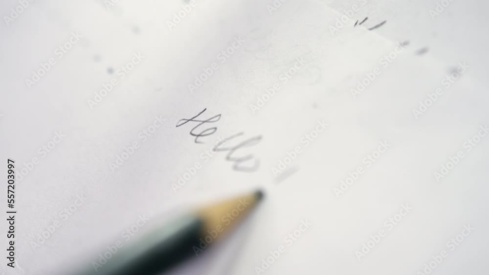 Person writes hello on blank sheet of paper with black pencil. Man ...