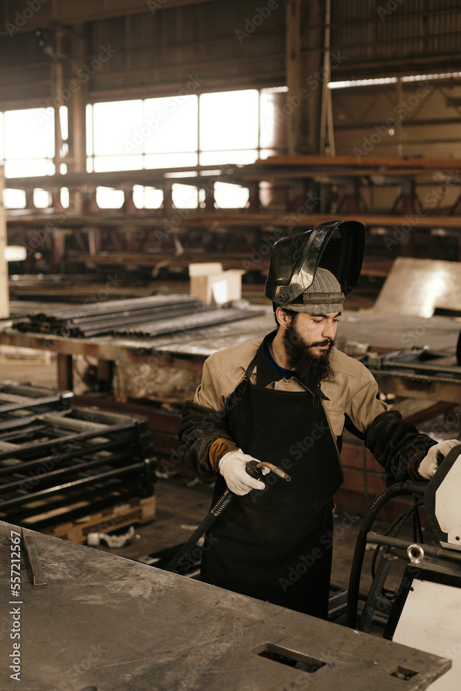Professional welder starting doing his job turning on welding torch ...