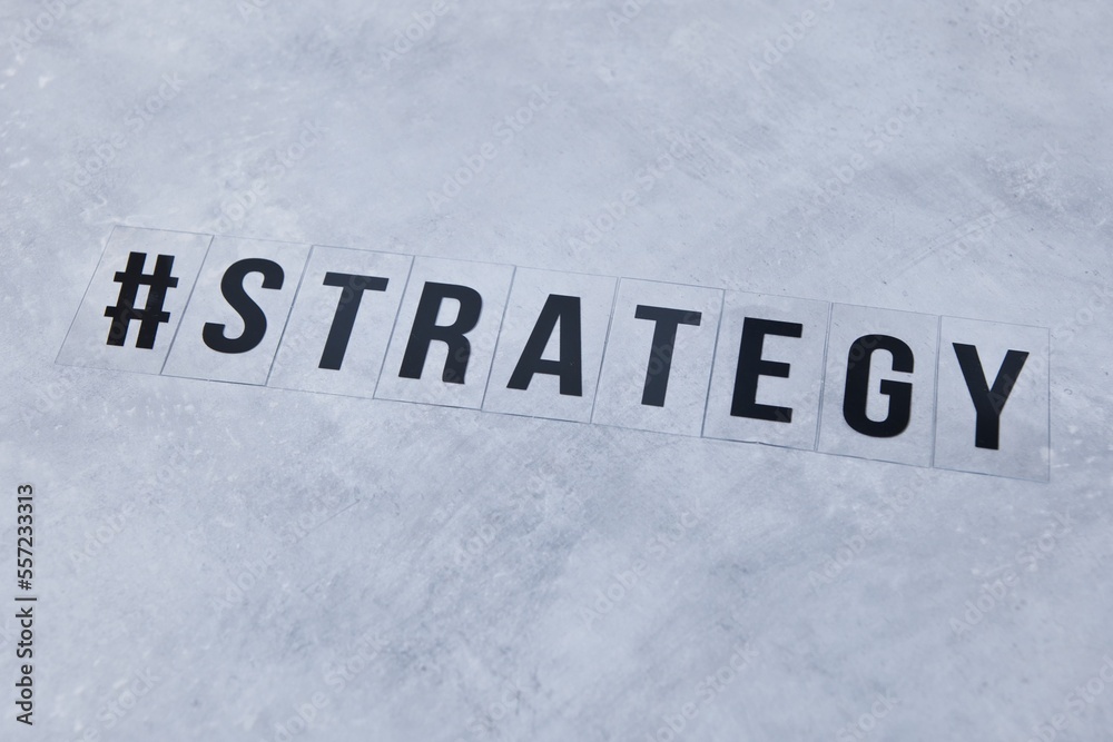 Black capital letters saying '#strategy' on concrete background ...