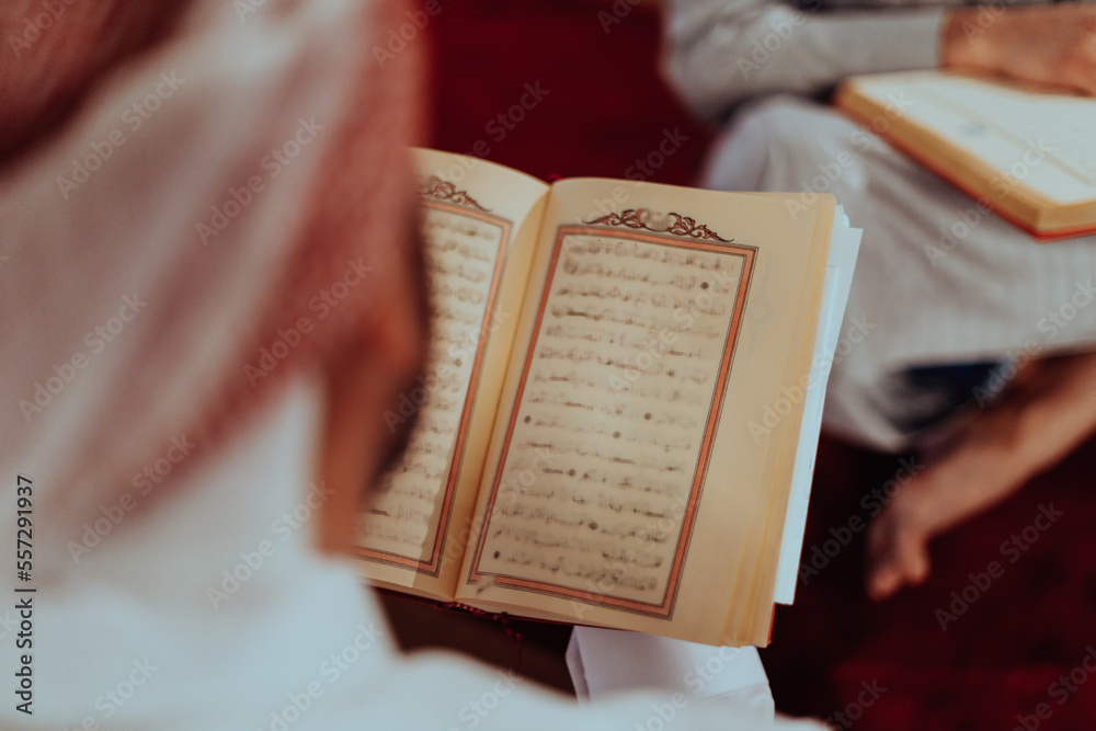 A group of Muslims reading the holy book of the Quran in a modern ...