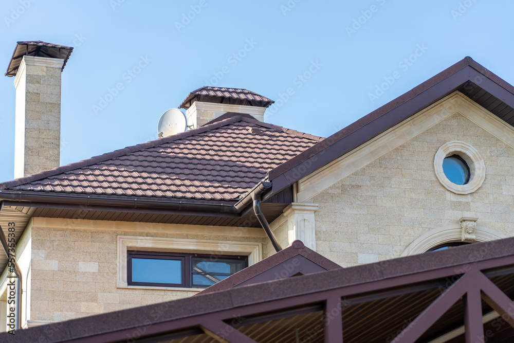Brown metal roof with chimney, smokestack and rain gutter with ...