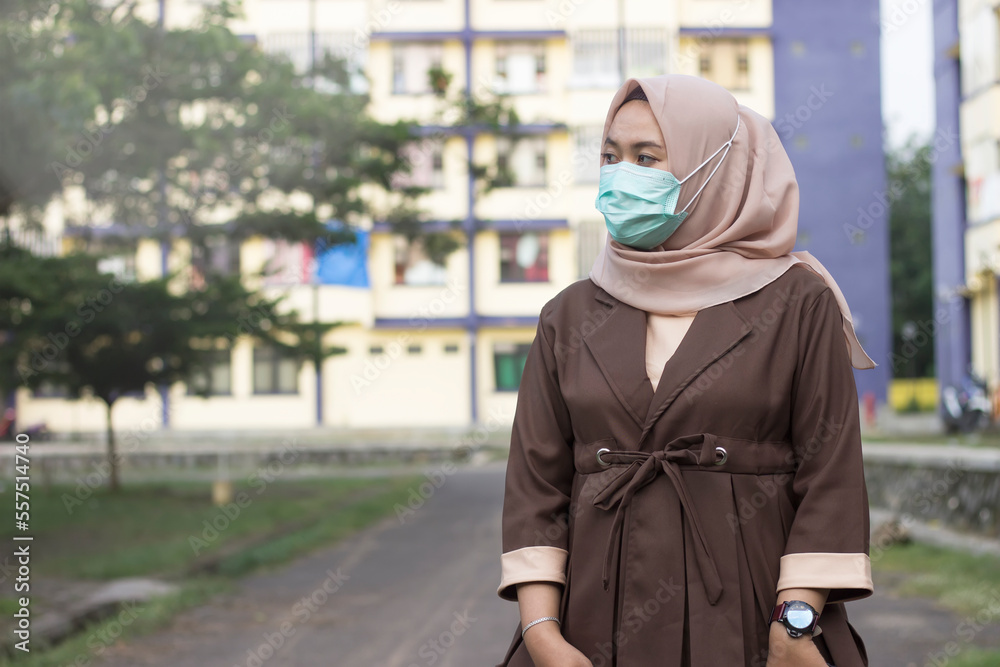Woman in hijab wears medical mask standing to protect her from air ...