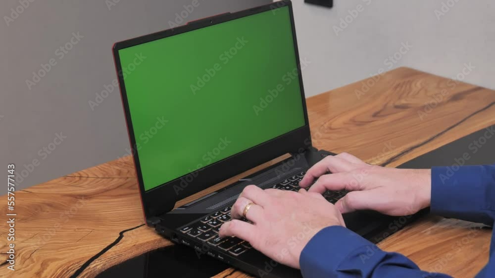 side view of a man behind a laptop. Over shoulder view of white male ...