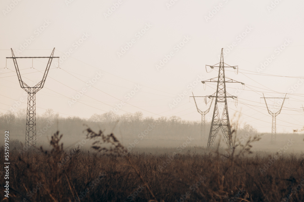 Power lines in the middle of a field with fog during the day. energy ...