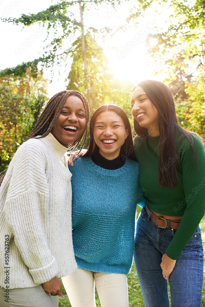 Vertical Portrait of three girls outside looking at the camera. An ...