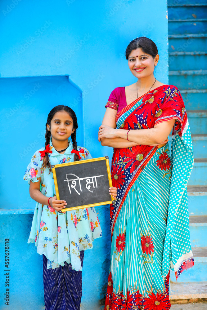 Education concept : Indian rural woman with her little daughter showing ...