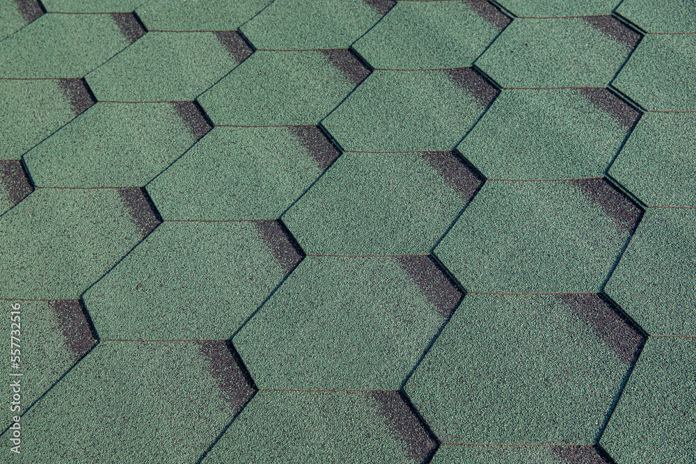 Roofing made of green soft bitumen tiles on a hipped roof of a house ...
